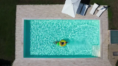 4K Woman floating on inflatable yellow r... | Stock Video | Pond5