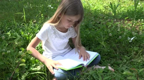4K Young Girl Reading Book on Meadow in ... | Stock Video | Pond5