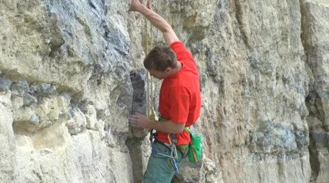 4K Young man climbing vertical rock face... | Stock Video | Pond5