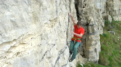 4K Young man climbing vertical rock face... | Stock Video | Pond5