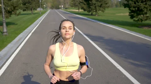 4K.Woman in yellow run on road. Listen m... | Stock Video | Pond5