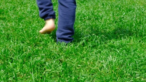 A 5-year-old boy walks barefoot on the g... | Stock Video | Pond5