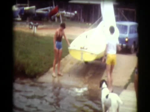 70's family Launching sailboat in lake | Stock Video | Pond5