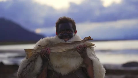 aboriginal eating fish. man in skins, fu... | Stock Video | Pond5
