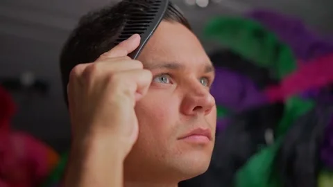Actor artist man combs his hair in the d... | Stock Video | Pond5