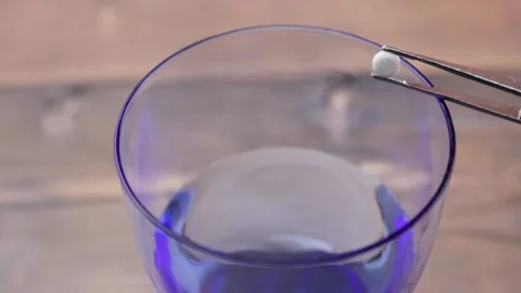 Add tablets to a glass of water. Throw t... | Stock Video | Pond5