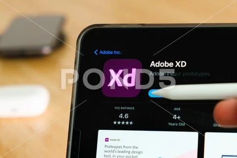 Adobe XD logo shown by apple pencil on the iPad Pro tablet screen. Man ...