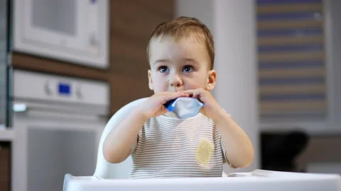 Adorable baby boy takes a pack of food i... | Stock Video | Pond5