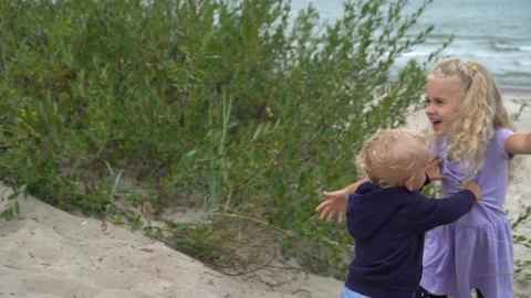 Adorable children fighting on dune sand.... | Stock Video | Pond5