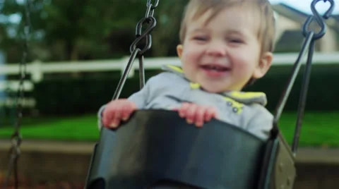 Adorable little boy on a swing, with a b... | Stock Video | Pond5