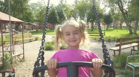 Adorable little girl on a fly swing smi... | Stock Video | Pond5