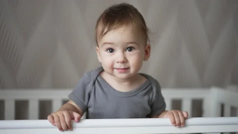 Adorable smiling baby boy standing in wh... | Stock Video | Pond5