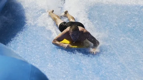 Adult man riding wave machine on a boogi... | Stock Video | Pond5