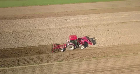 aerial above red tractor plowing prepari... | Stock Video | Pond5