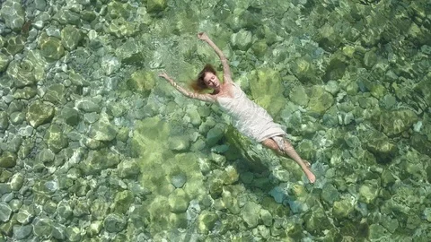 Aerial of beautiful woman floating on th... | Stock Video | Pond5