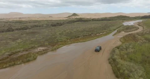 Aerial: Car driving in a stream in the T... | Stock Video | Pond5
