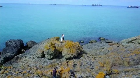 Aerial Of Couple On Cliff next to sea an... | Stock Video | Pond5