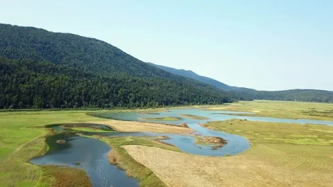 AERIAL: Curved lake with beautiful mount... | Stock Video | Pond5