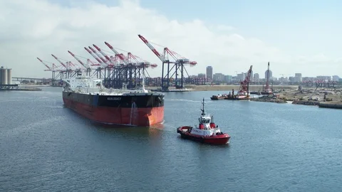 Aerial of tugboat pulling cargo ship awa... | Stock Video | Pond5