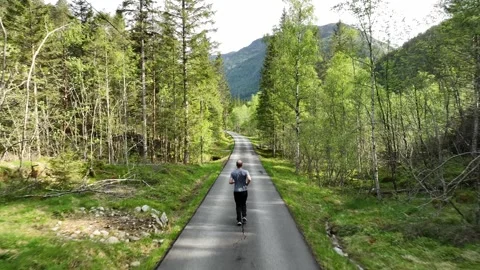 Aerial view following man jogging on pav... | Stock Video | Pond5