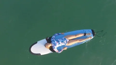 aerial view pretty girl lies on a surf o... | Stock Video | Pond5