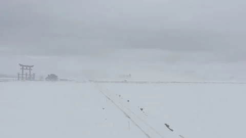 Aerial view of a snowy land with a torii... | Stock Video | Pond5
