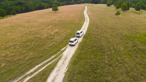 aerial view of two white suv car ride by... | Stock Video | Pond5