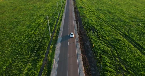 Aerial view of a white car moving along ... | Stock Video | Pond5