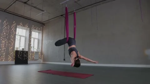 Aerial yoga - a young woman hanging upsi... | Stock Video | Pond5