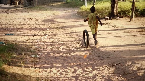 Africa kid playing with old tyre in nati... | Stock Video | Pond5