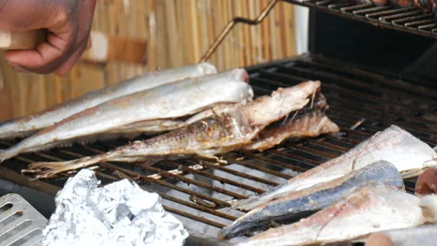 An African American cooks raw fish on th... | Stock Video | Pond5