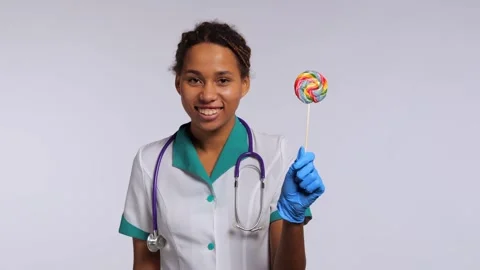 african nurse holding candy in hands | Stock Video | Pond5