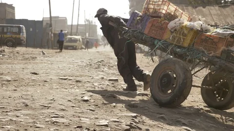 An African old man pulling a hand cart o... | Stock Video | Pond5