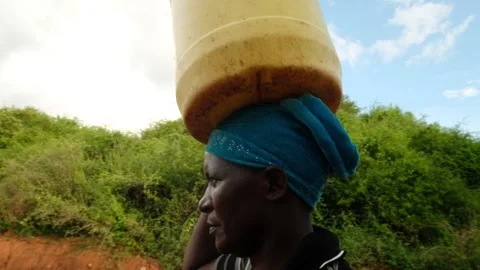 African Woman Carrying Water in Barrel | Stock Video | Pond5