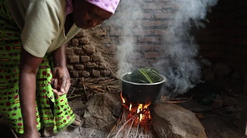 African woman cooking over a fuel wood s... | Stock Video | Pond5