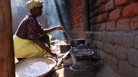 African woman cooking over an open fire ... | Stock Video | Pond5