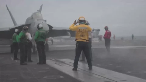 Aircraft handler guiding F/A-18 Hornet a... | Stock Video | Pond5