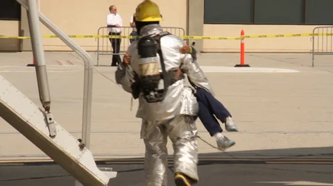 Airport firefighter carrying victim in h... | Stock Video | Pond5