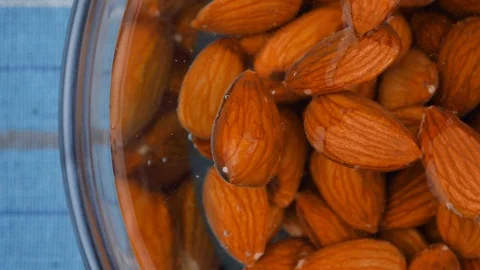 Almond nuts float in water in a glass bo... | Stock Video | Pond5