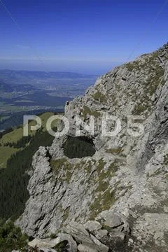 Alpine hiking trail through an erosional hole at the "three sisters ...