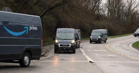 Amazon delivery trucks drive onto the st... | Stock Video | Pond5
