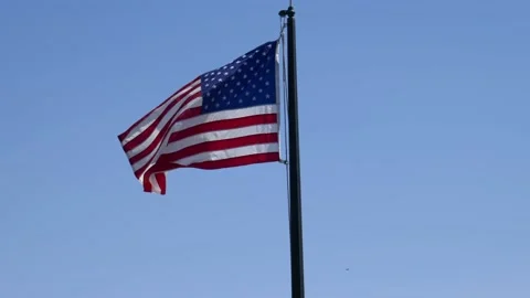 American flag blowing in the wind over c... | Stock Video | Pond5