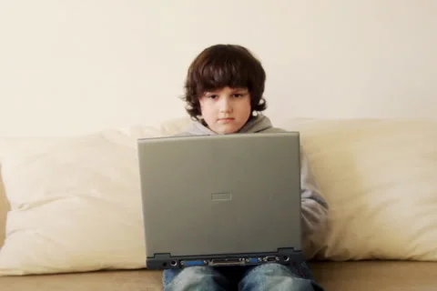 Angry boy sitting on sofa with laptop | Stock Video | Pond5