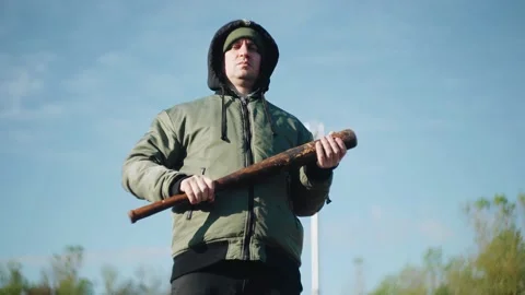 Angry guy in a hooded jacket and a baseb... | Stock Video | Pond5