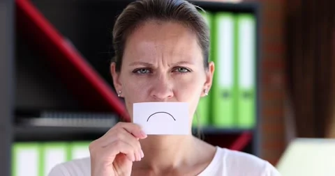 Angry sad woman holding paper sad smiley | Stock Video | Pond5