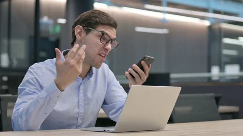 Angry Young Man with Laptop Talking on P... | Stock Video | Pond5
