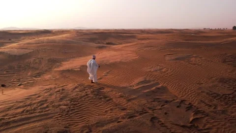 Arab man walking barefoot through the de... | Stock Video | Pond5