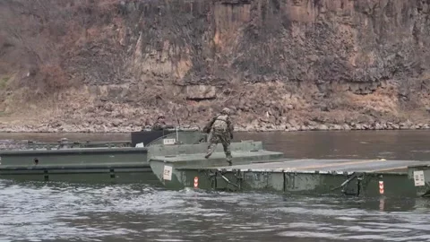 Army soldiers attach floating bridge sec... | Stock Video | Pond5
