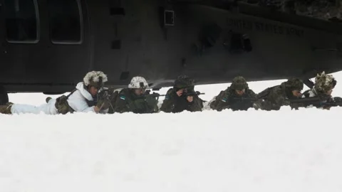 Army soldiers lying on snow by UH-60 Bla... | Stock Video | Pond5