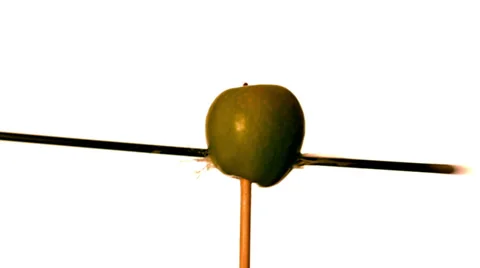 Arrow shooting through green apple on wh... | Stock Video | Pond5